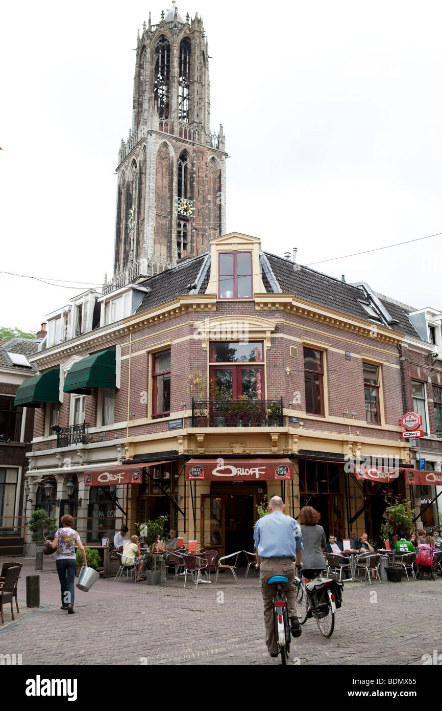OLd town Utrecht with cathedral clock tower and people riding bikes ...