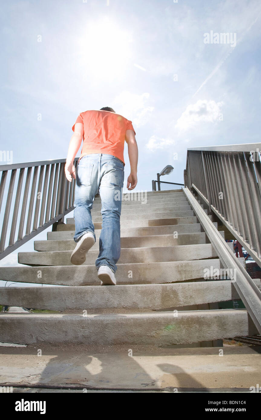 Young man ascending a pedestrian bridge Stock Photo - Alamy