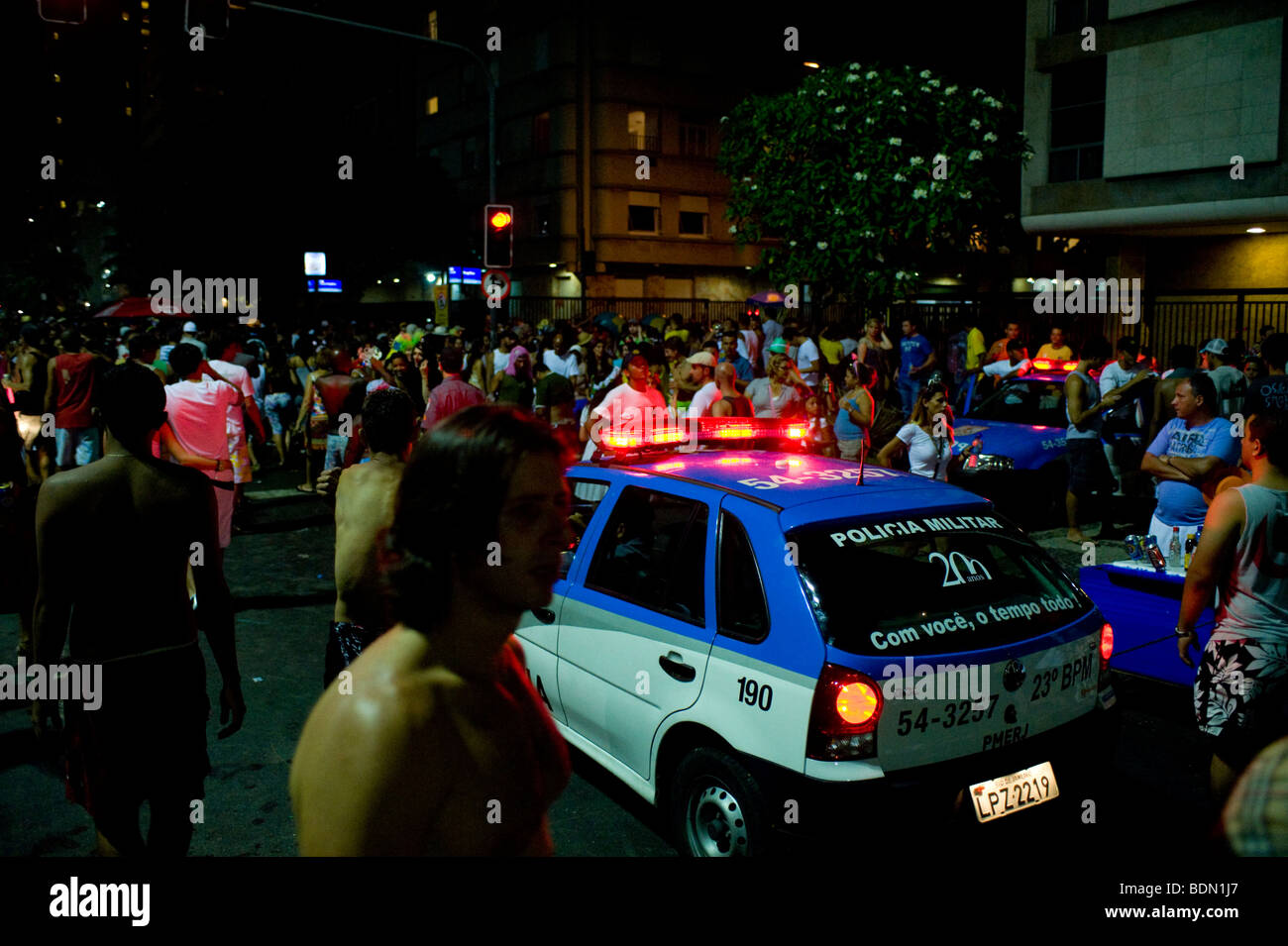 A police car amongst crowds of people at night at the Carnival in the ...