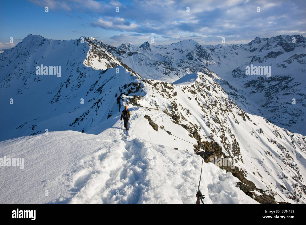 Secured climber on a fixed rope route in the high mountains in winter ...