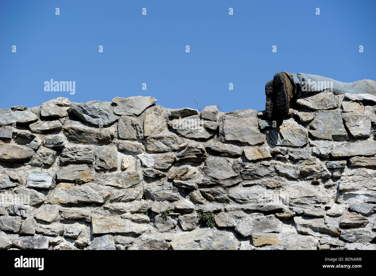 Feet dangling over wall Stock Photo - Alamy
