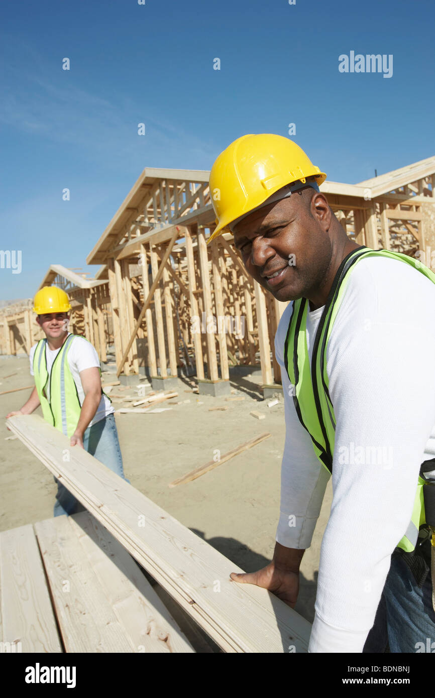 Construction Workers Stacking Timber Stock Photo - Alamy