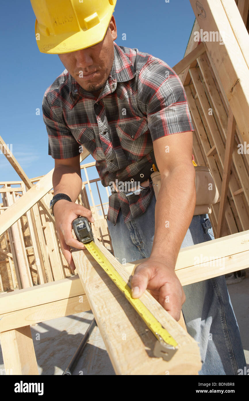 Construction Worker Measuring Timber Stock Photo - Alamy