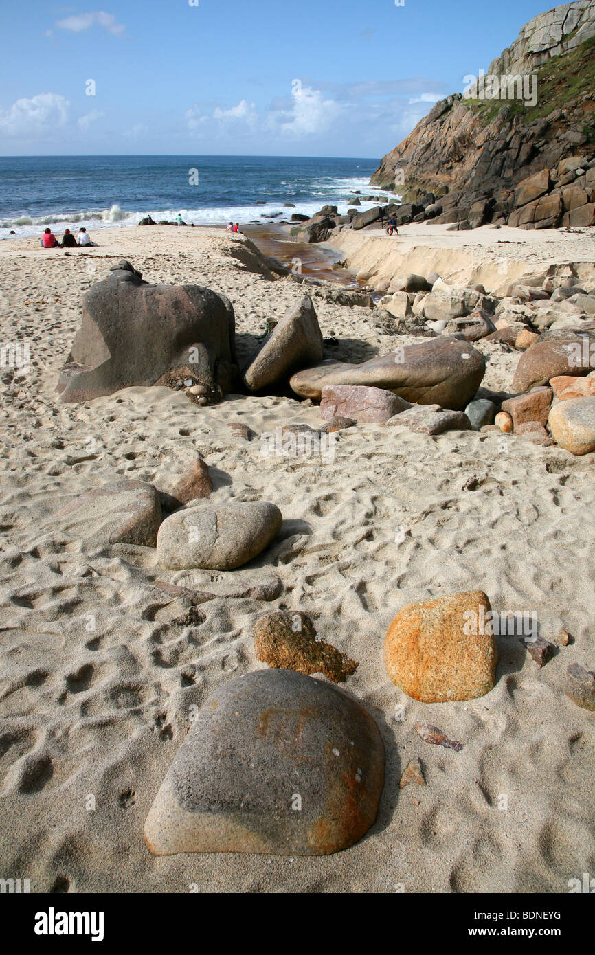 People relaxing on the beach of a sandy cove on the rocky coast near ...