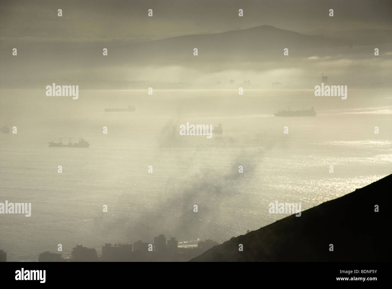 Three ships in misty Table Bay with silhouette of city buildings in ...