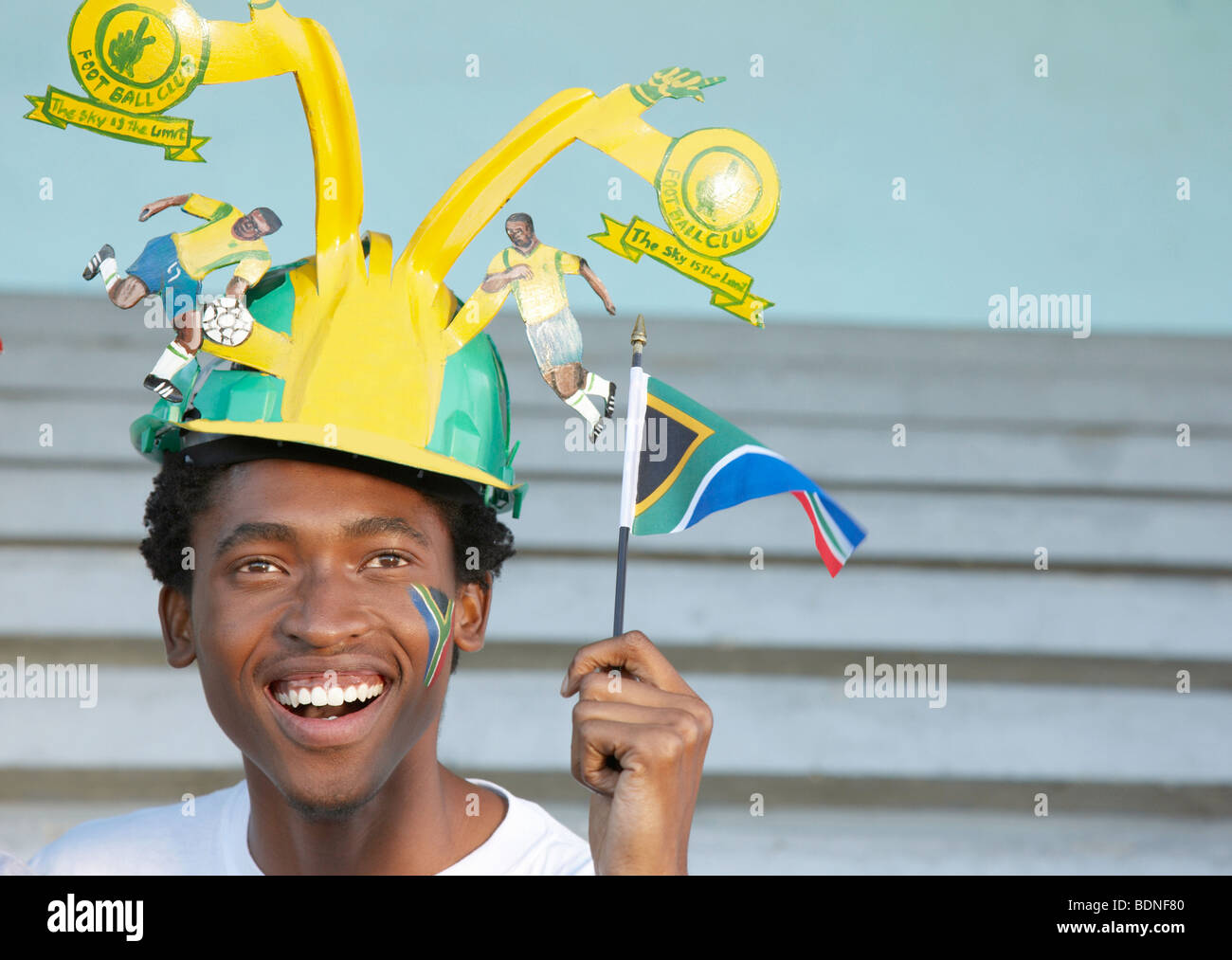 Sports fan wearing makarapa hat and waving small South African flag ...