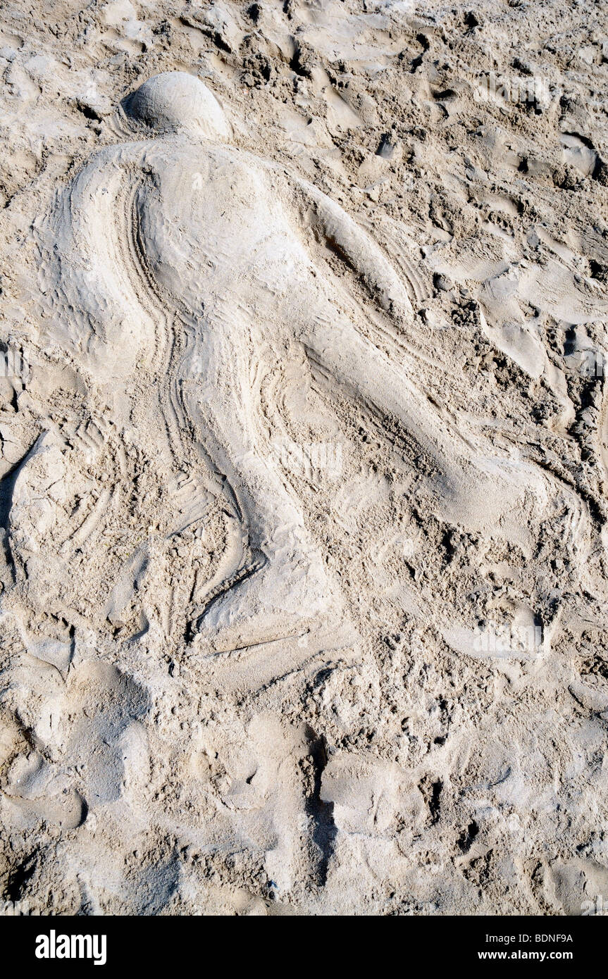 A sculptured sand creation of a person on the beach at Sandbanks in ...