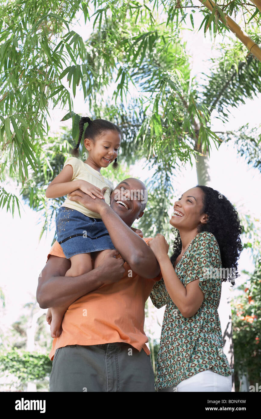 Parents with daughter (5-6 years) in tropical forest, low angle view ...