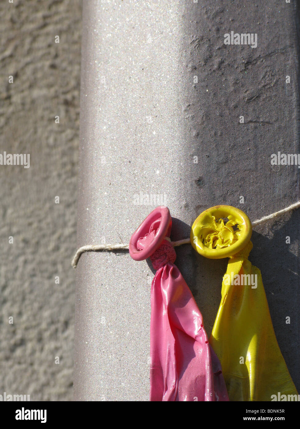 three burst balloons tied to lamp post outdoors in sun Stock Photo - Alamy