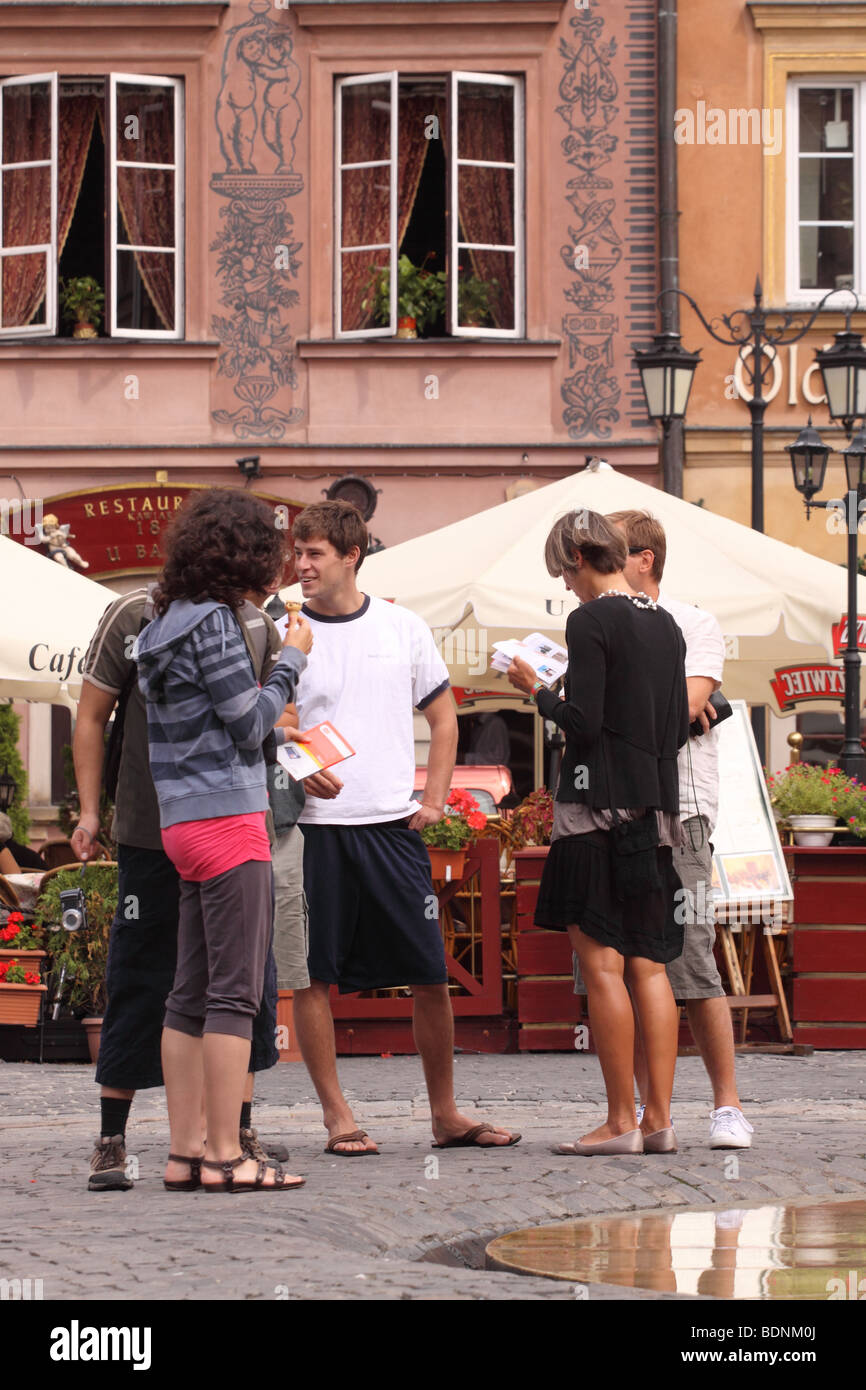 Warsaw Poland young tourists in the Old Town square with open air cafes ...