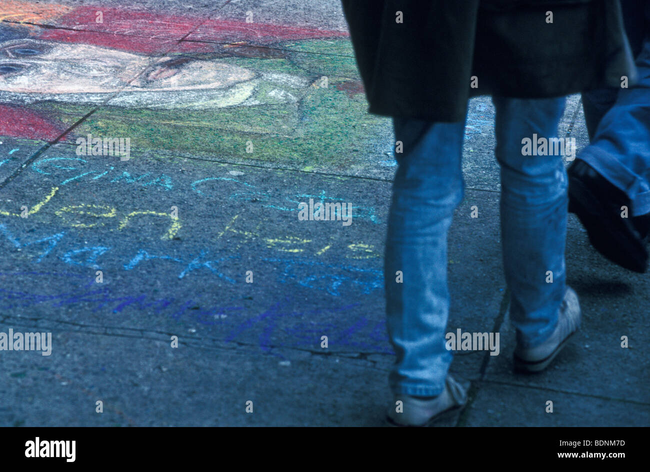 pedestrians walk by sidewalk graffiti Stock Photo - Alamy
