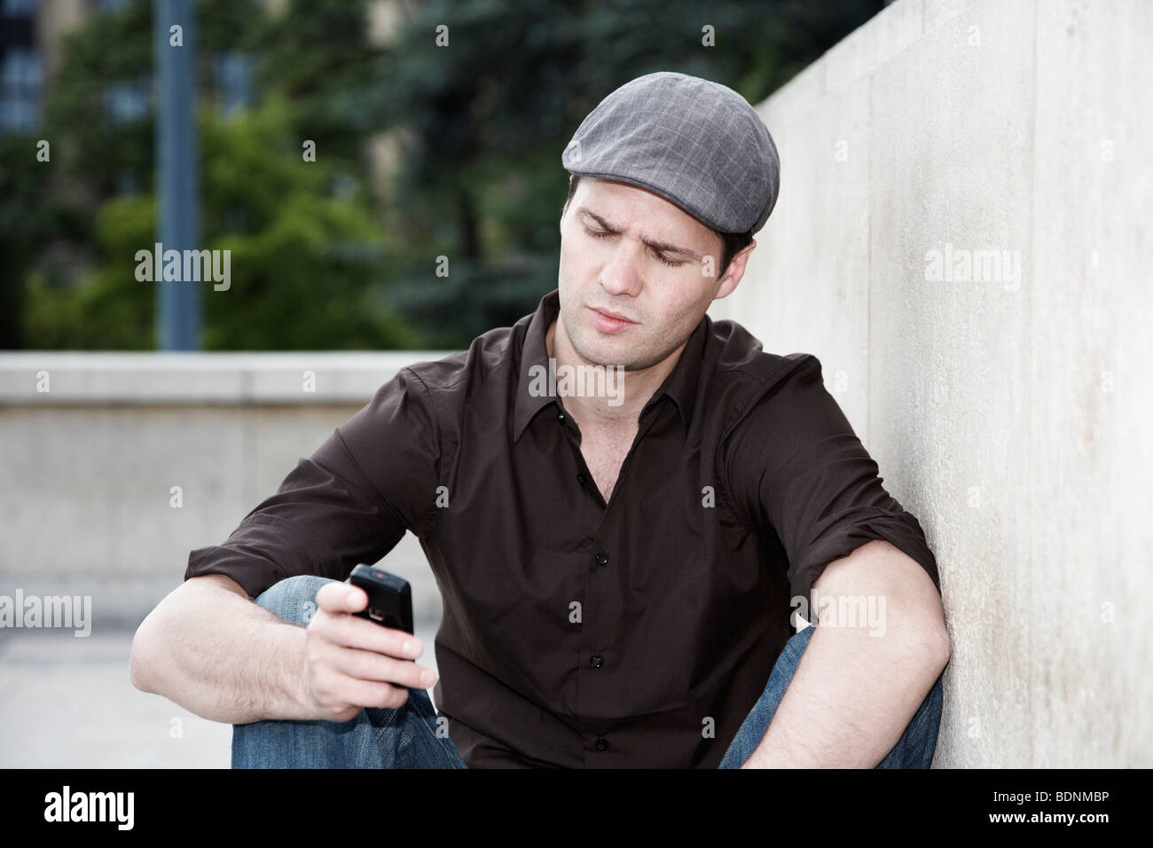 Young man reading a text message on his mobile phone Stock Photo - Alamy
