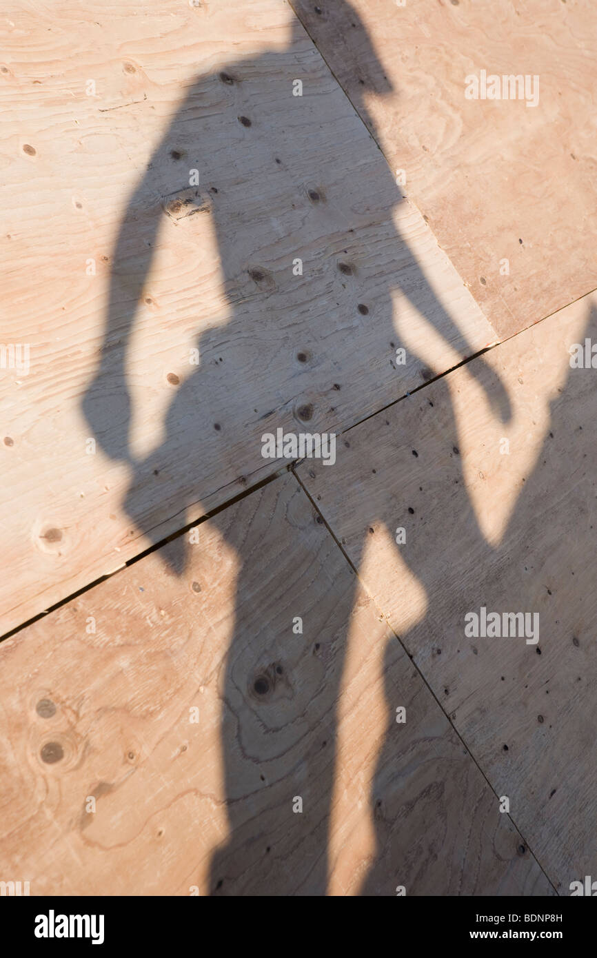 Shadow of carpenter on the roof of an under construction house Stock ...