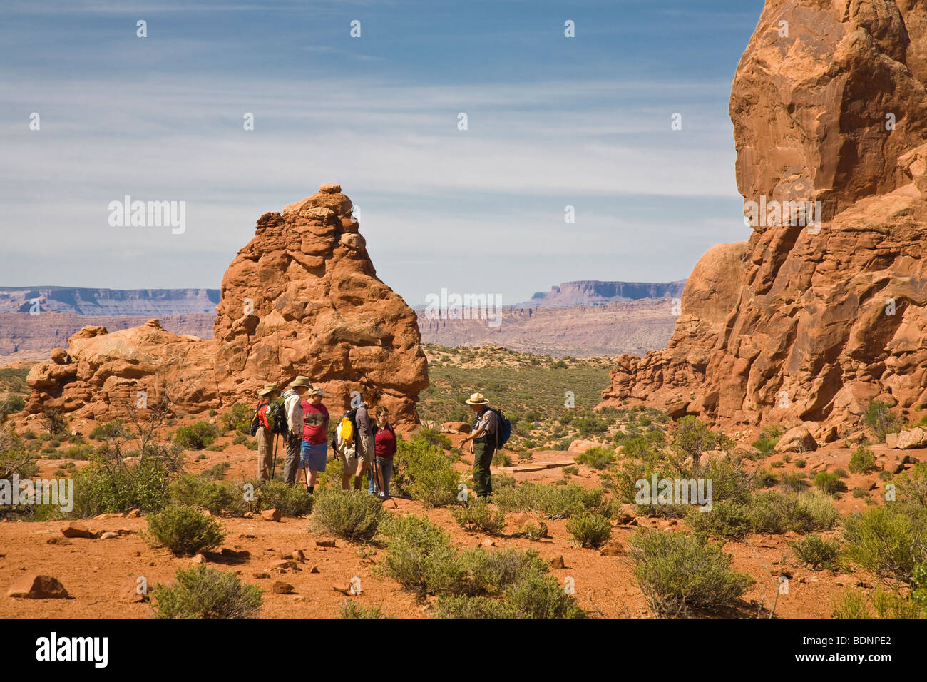 Park Ranger leading group of tourists in the Windows Section of Arches ...