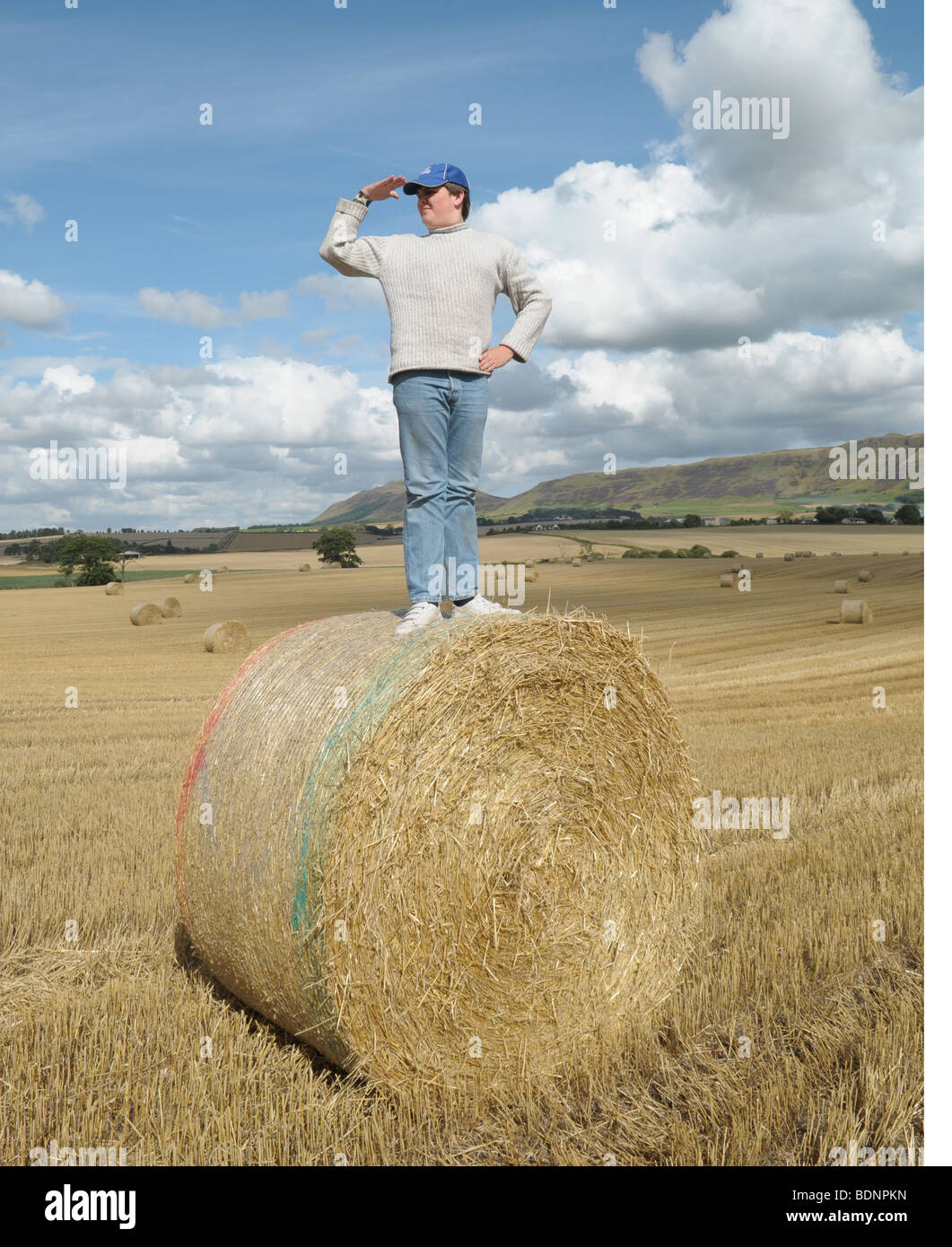 A young boy in a field with hay bales Stock Photo - Alamy