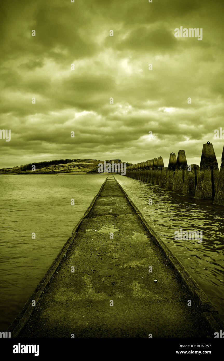 A concrete jetty on water under a stormy sky Stock Photo - Alamy