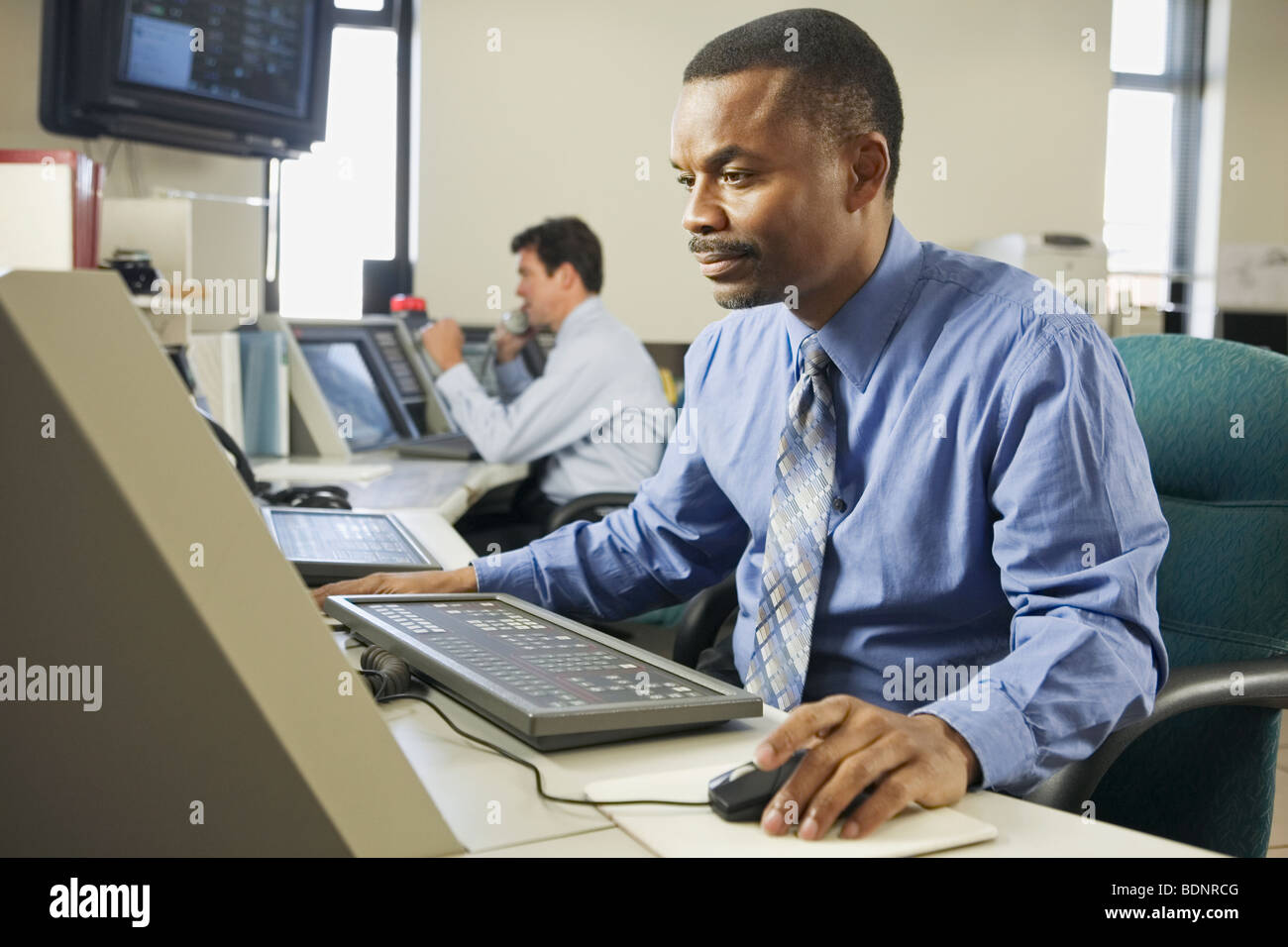 Two operating engineers working in a control room Stock Photo - Alamy