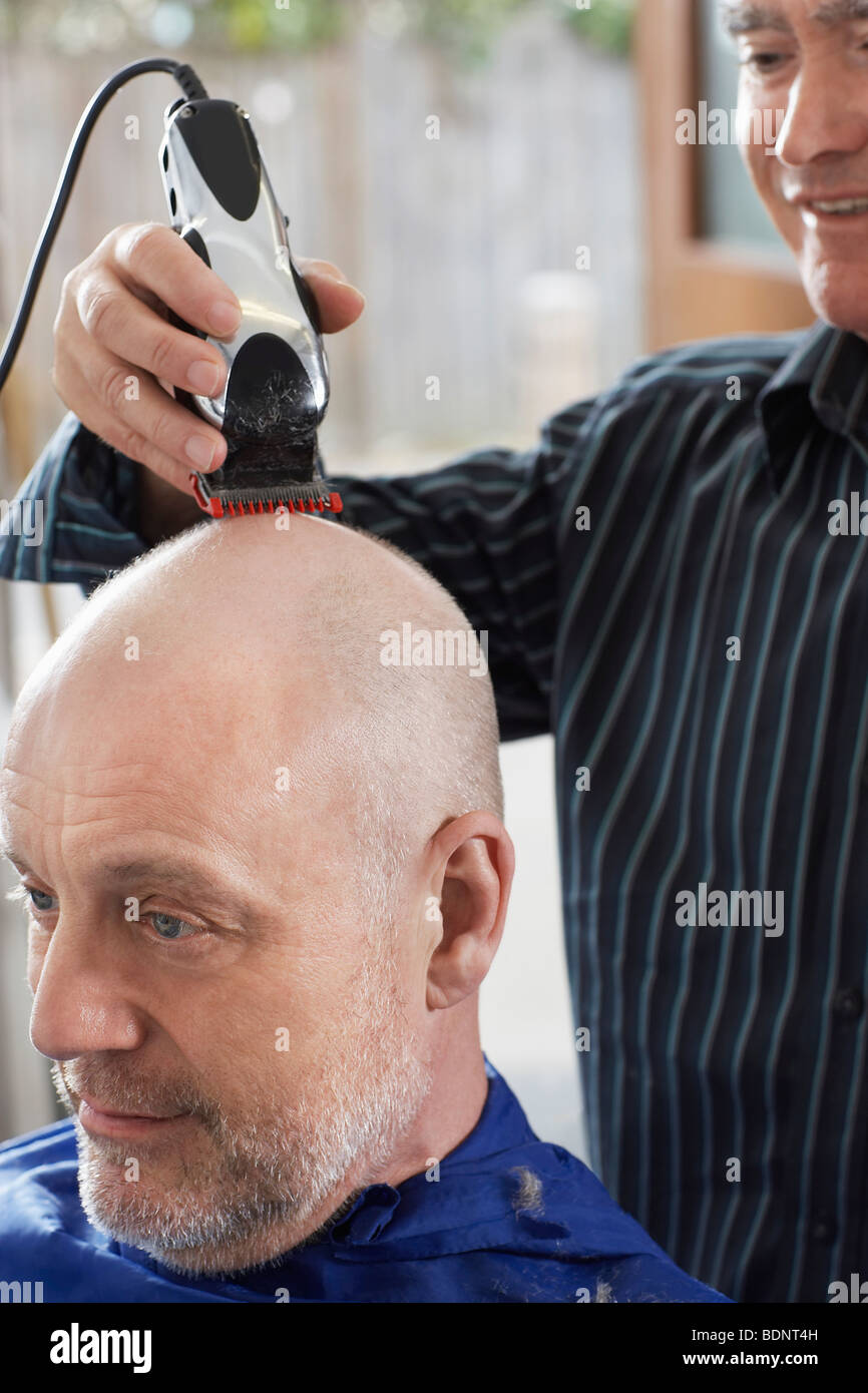 Barber shaving mans head in barber shop Stock Photo - Alamy