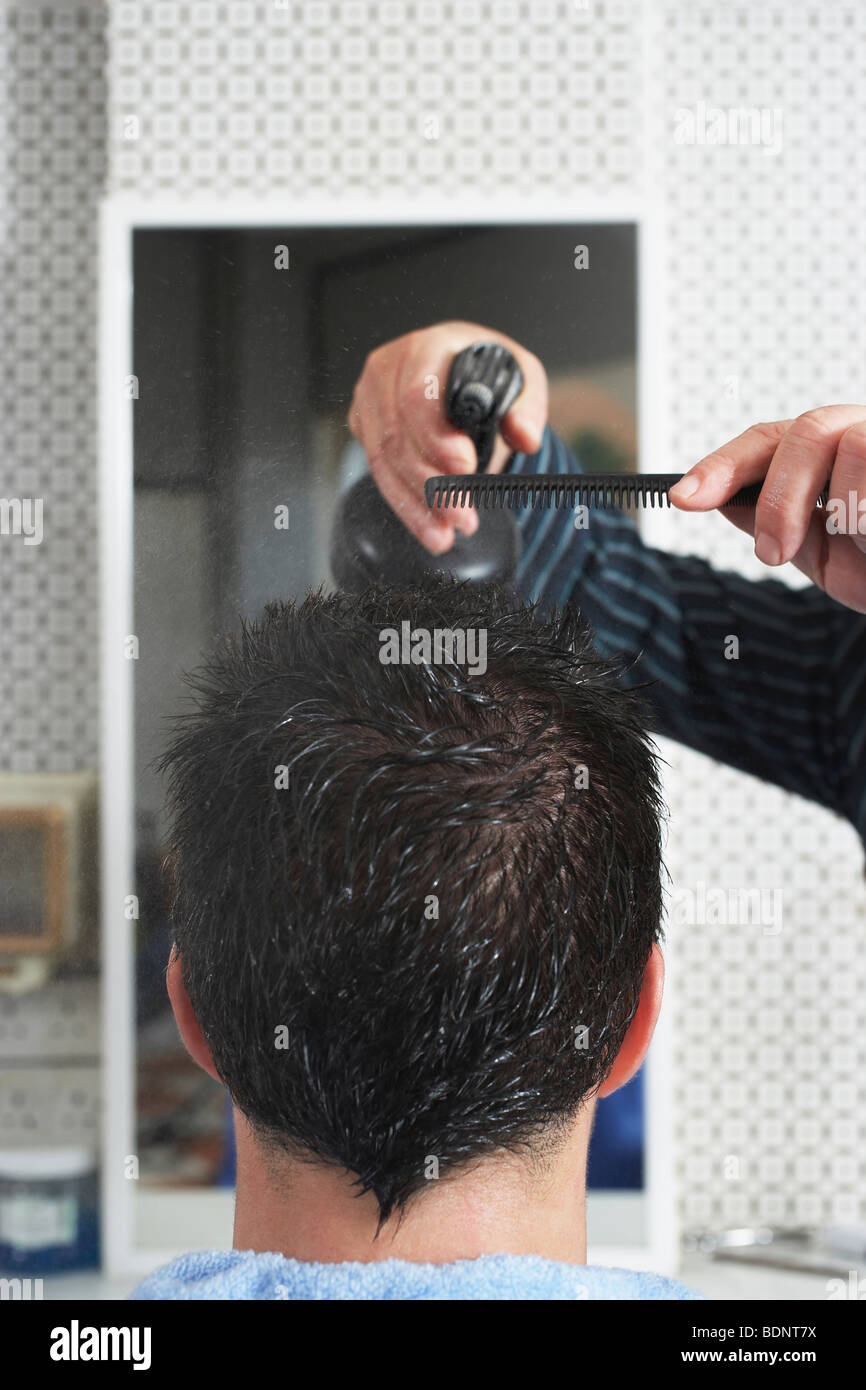 Barber spraying mans hair in barber shop, close-up Stock Photo - Alamy