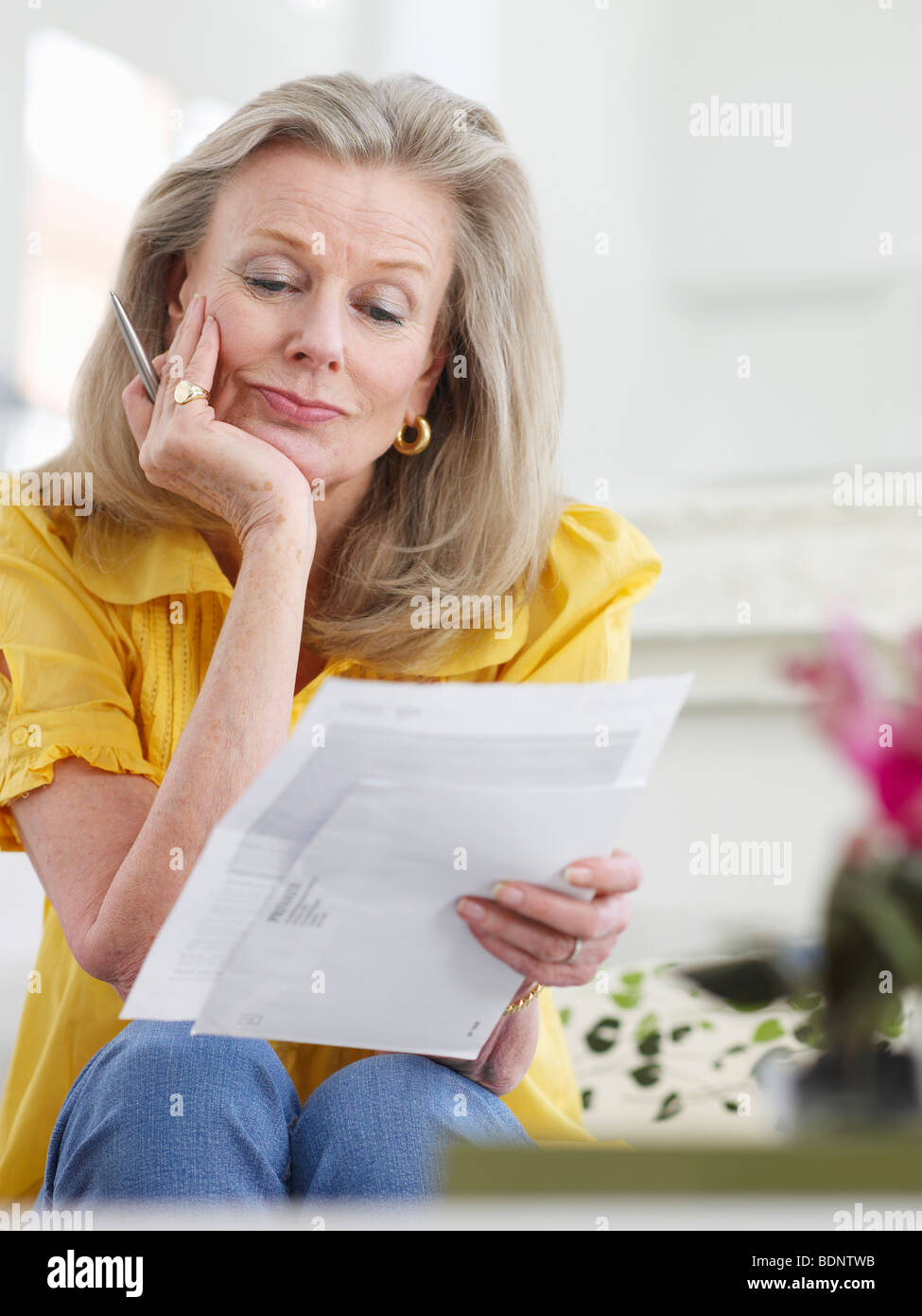 Woman reading paper documents indoors Stock Photo - Alamy