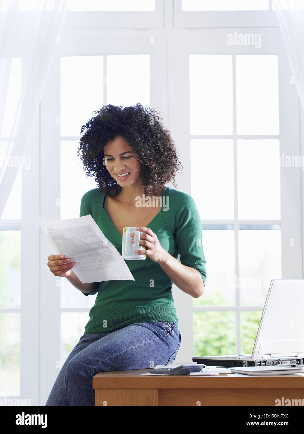 Woman reading document at home Stock Photo - Alamy