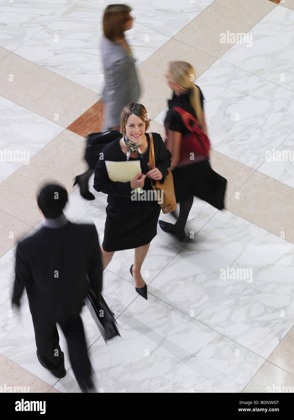 Business woman standing amongst people walking, elevated view, long ...