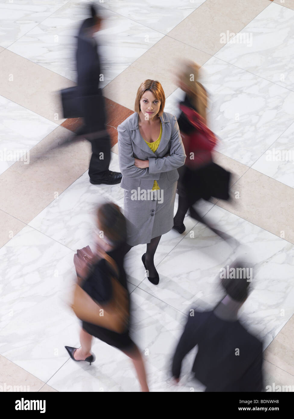 Business woman standing amongst people walking, elevated view, long ...