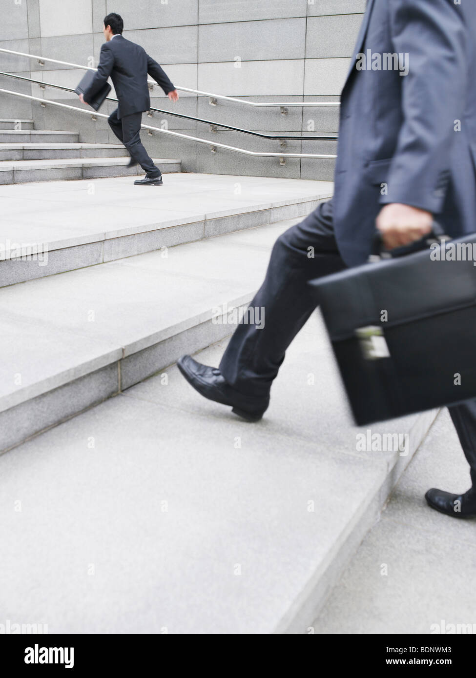 Business men hurrying up steps, outdoors, side view Stock Photo - Alamy