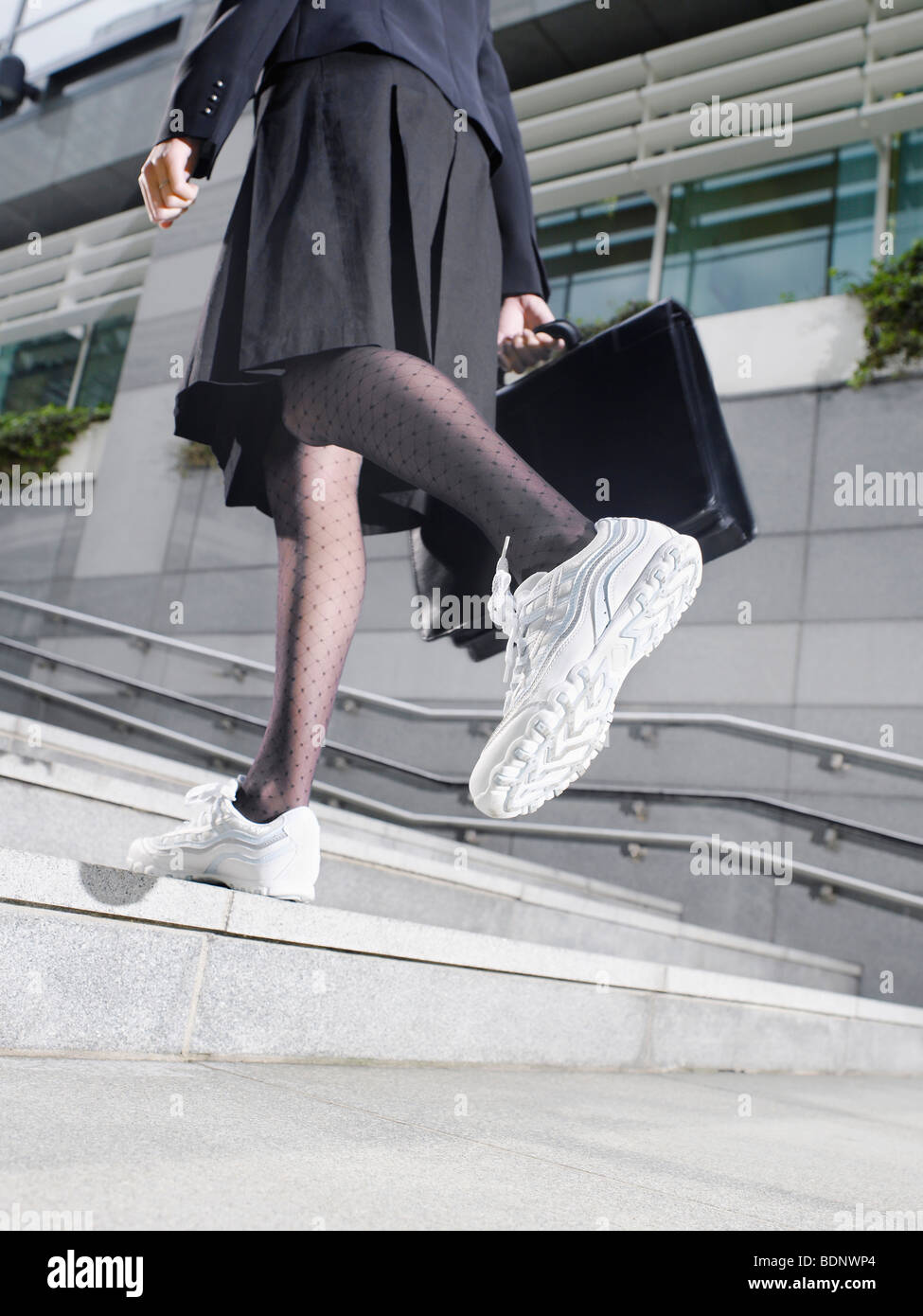 Woman walking suit trainers hi-res stock photography and images - Alamy