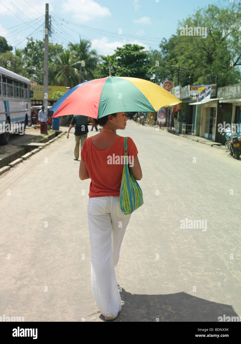 Young woman on road, walking with umbrella, back view Stock Photo - Alamy