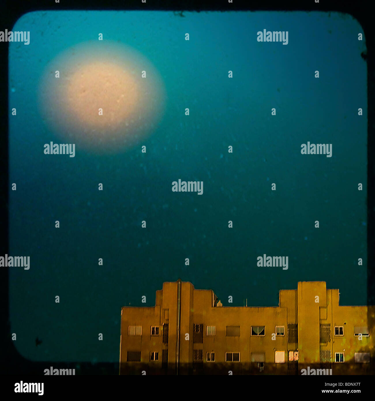 The Moon shining in a blue sky over a block of flats Stock Photo - Alamy