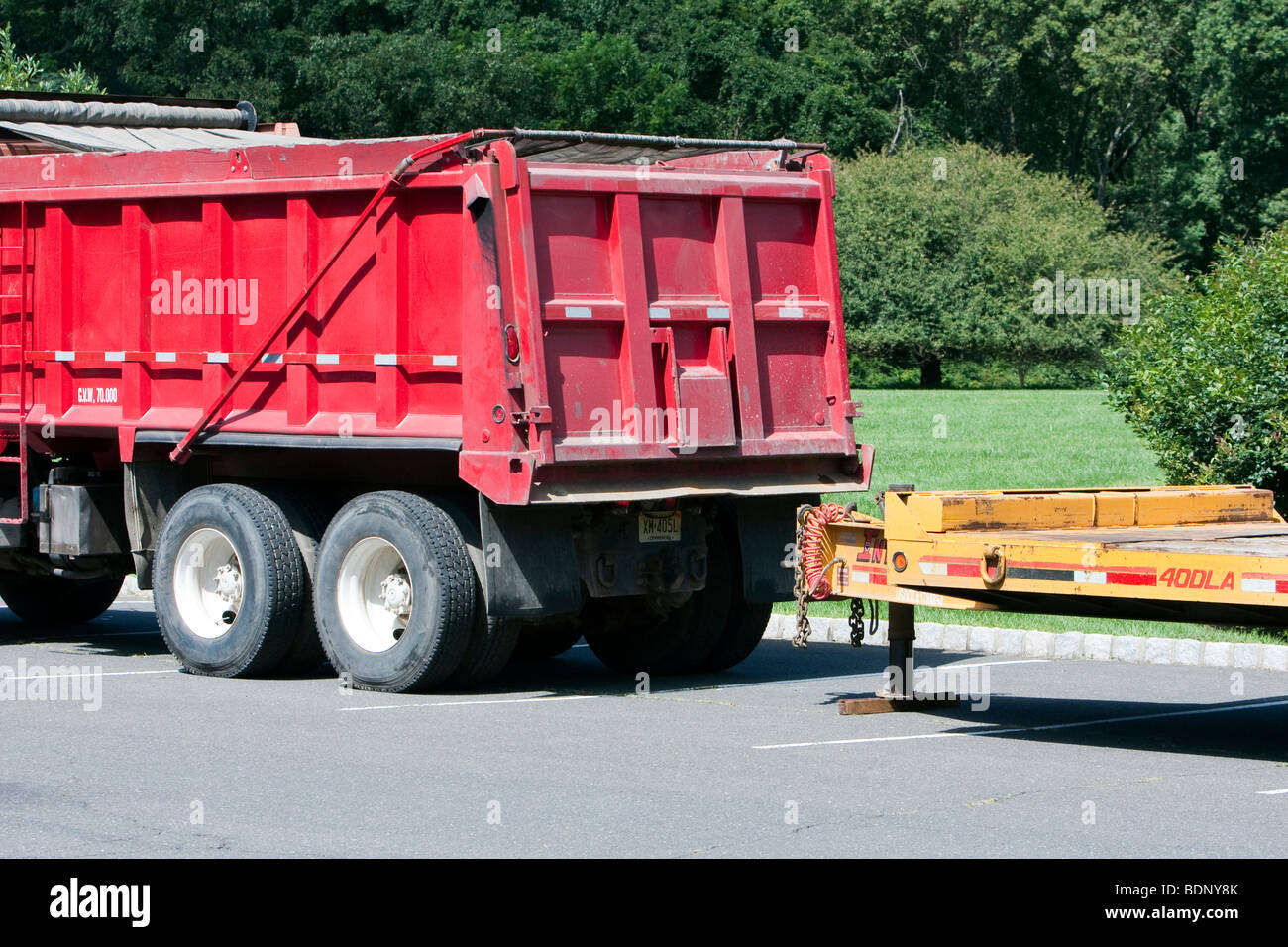 Unhooking a yellow trailer from a a big red dump truck Stock Photo - Alamy