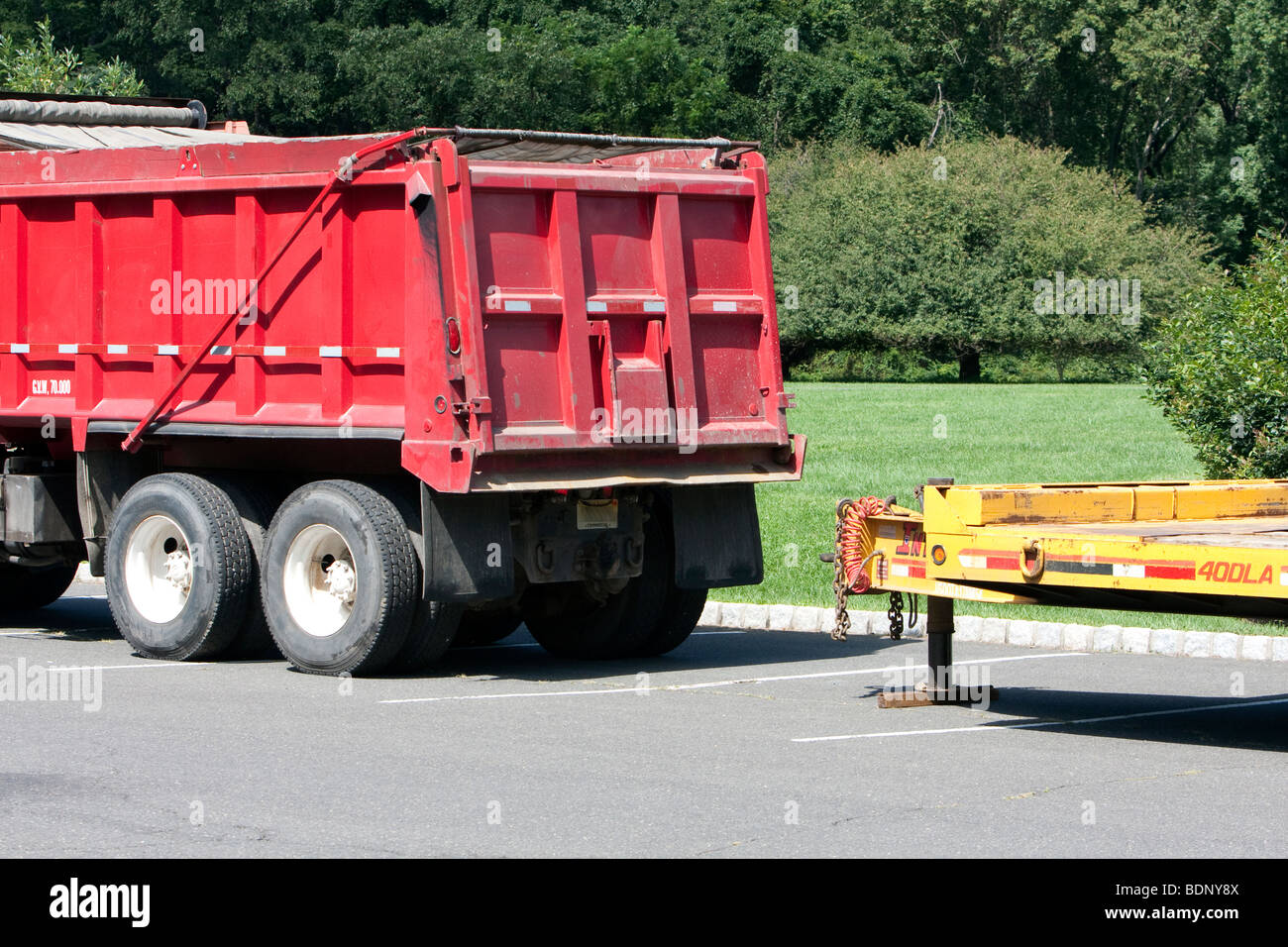 Unhooking a yellow trailer from a a big red dump truck Stock Photo - Alamy