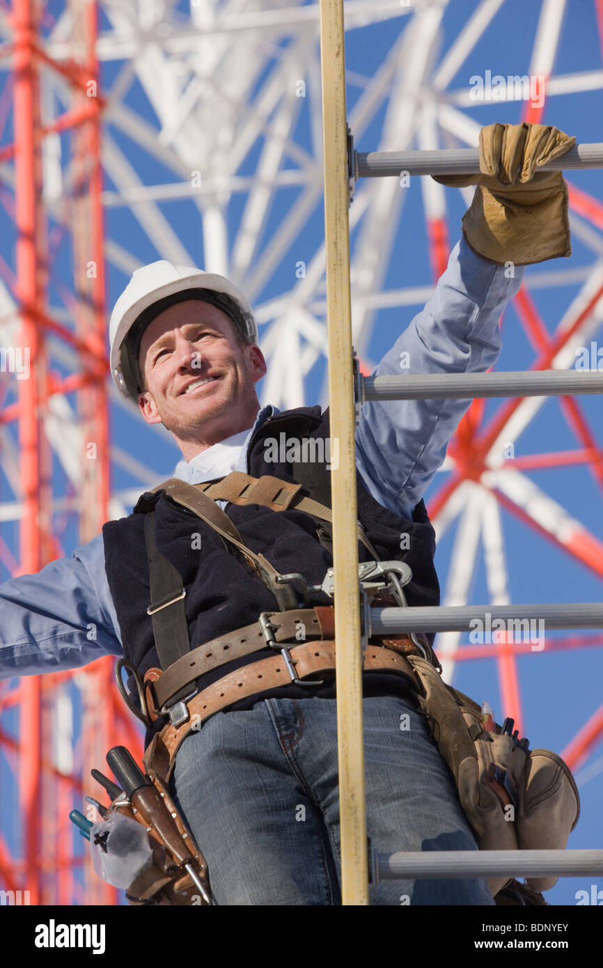 Cable lineman climbing a ladder to repair transmission line Stock Photo ...