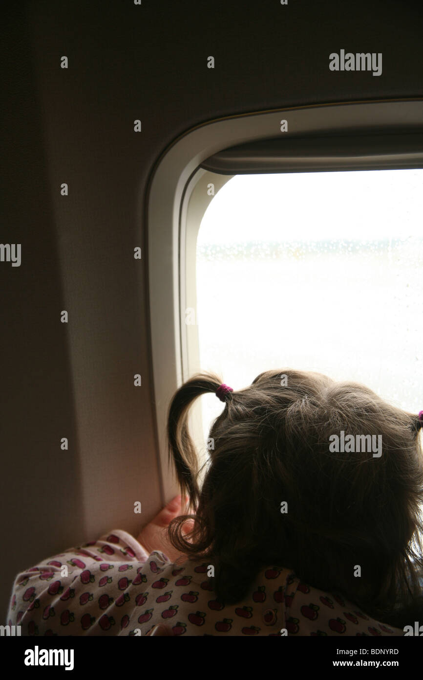 Toddler looking out airplane window Stock Photo - Alamy