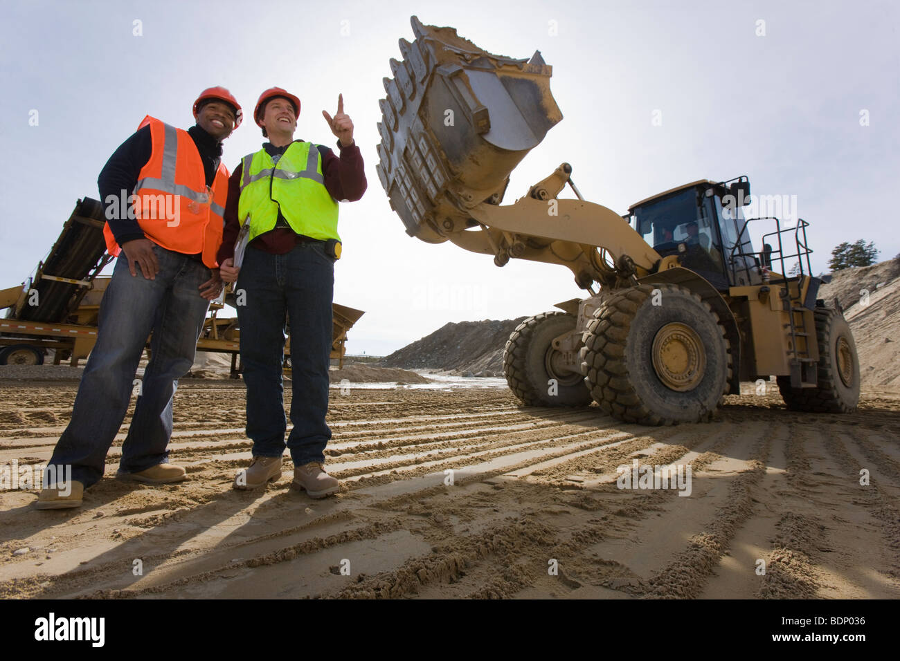 Two engineers near a front-end loader Stock Photo - Alamy