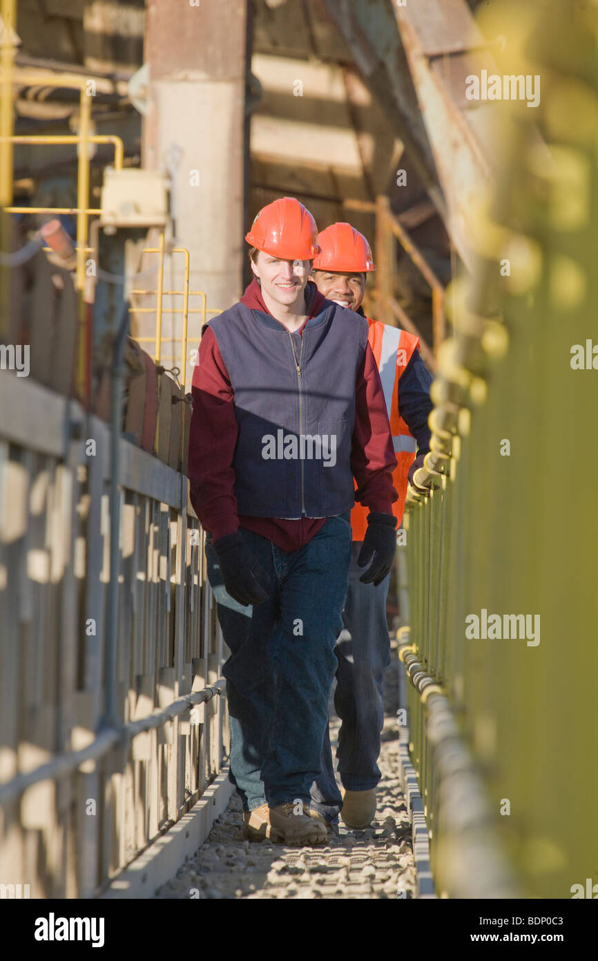 Two engineers standing on a conveyor belt at a construction site Stock ...