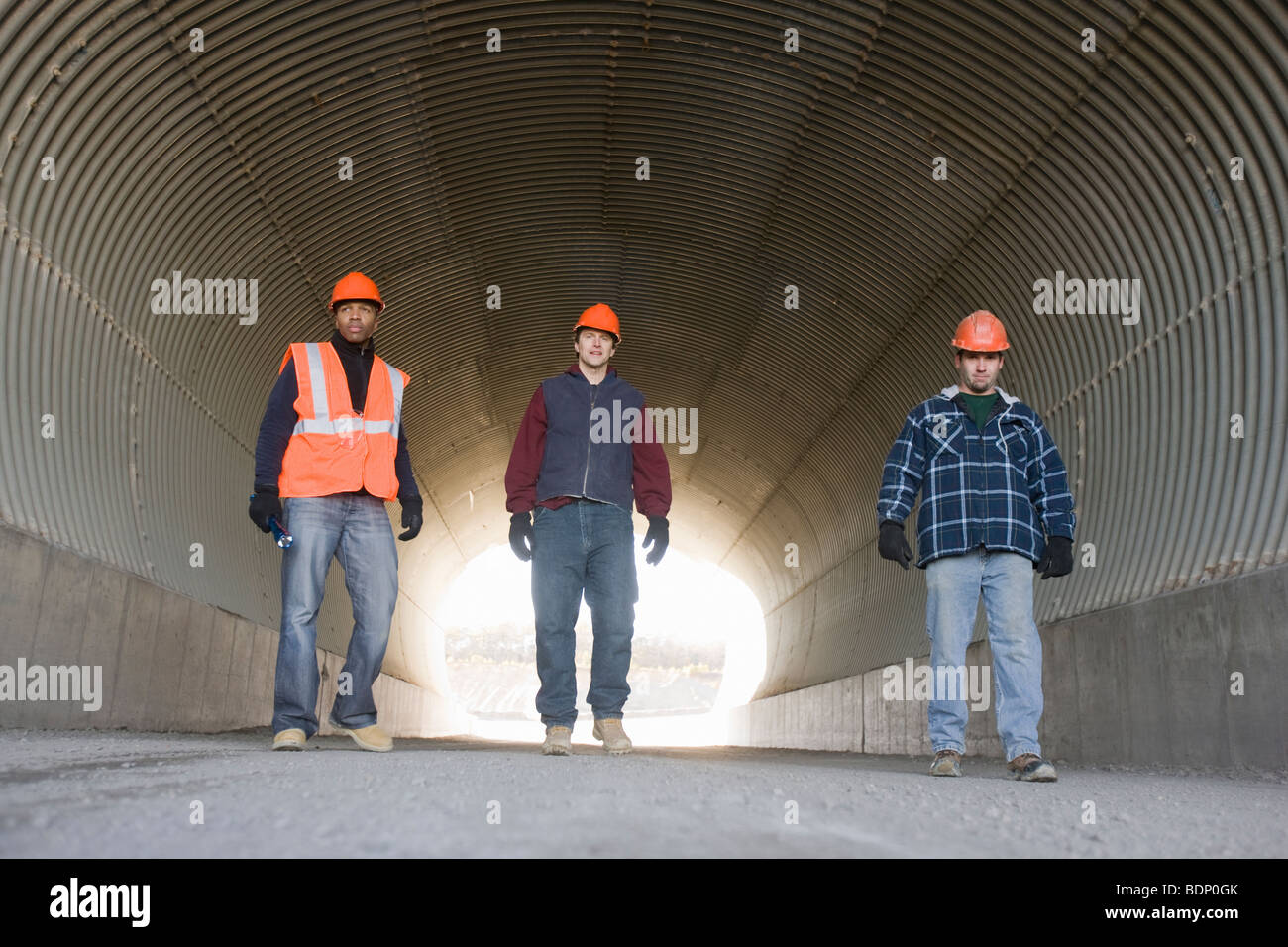 Three engineers walking in a tunnel Stock Photo - Alamy