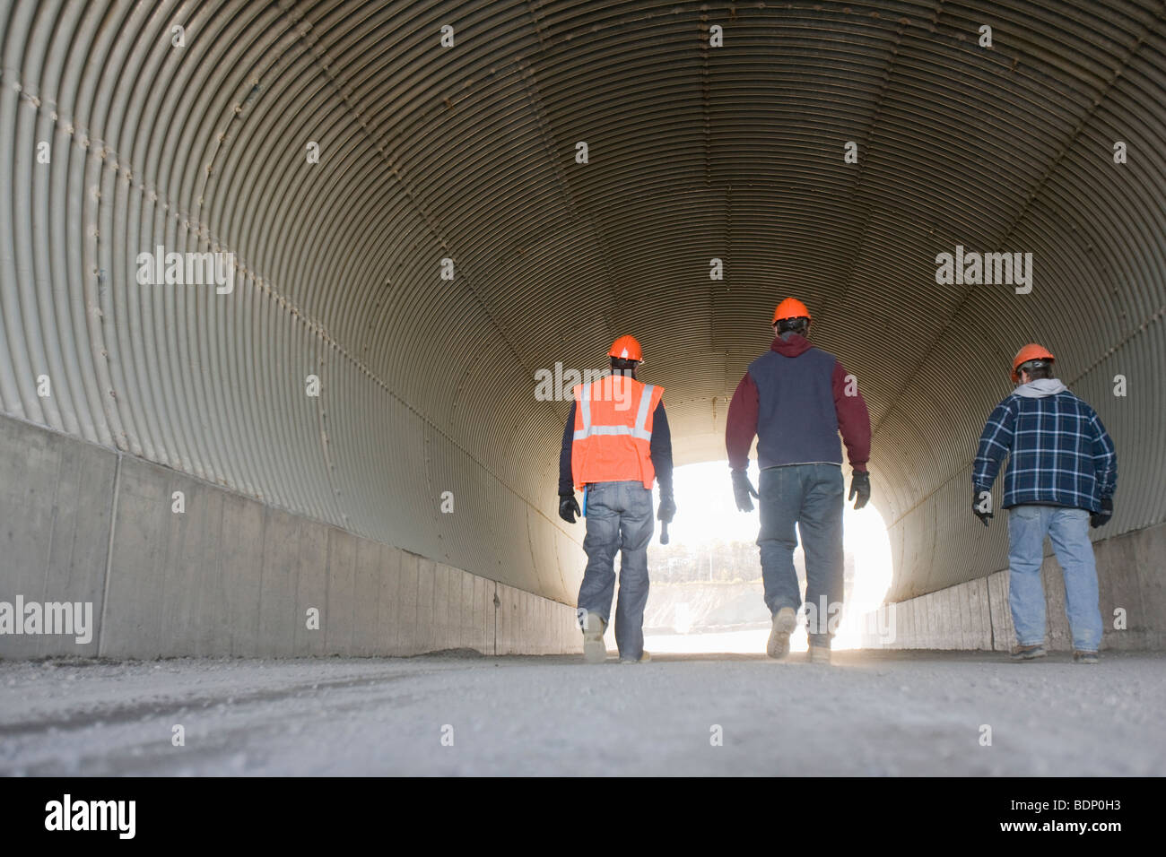 Three engineers walking in a tunnel Stock Photo - Alamy