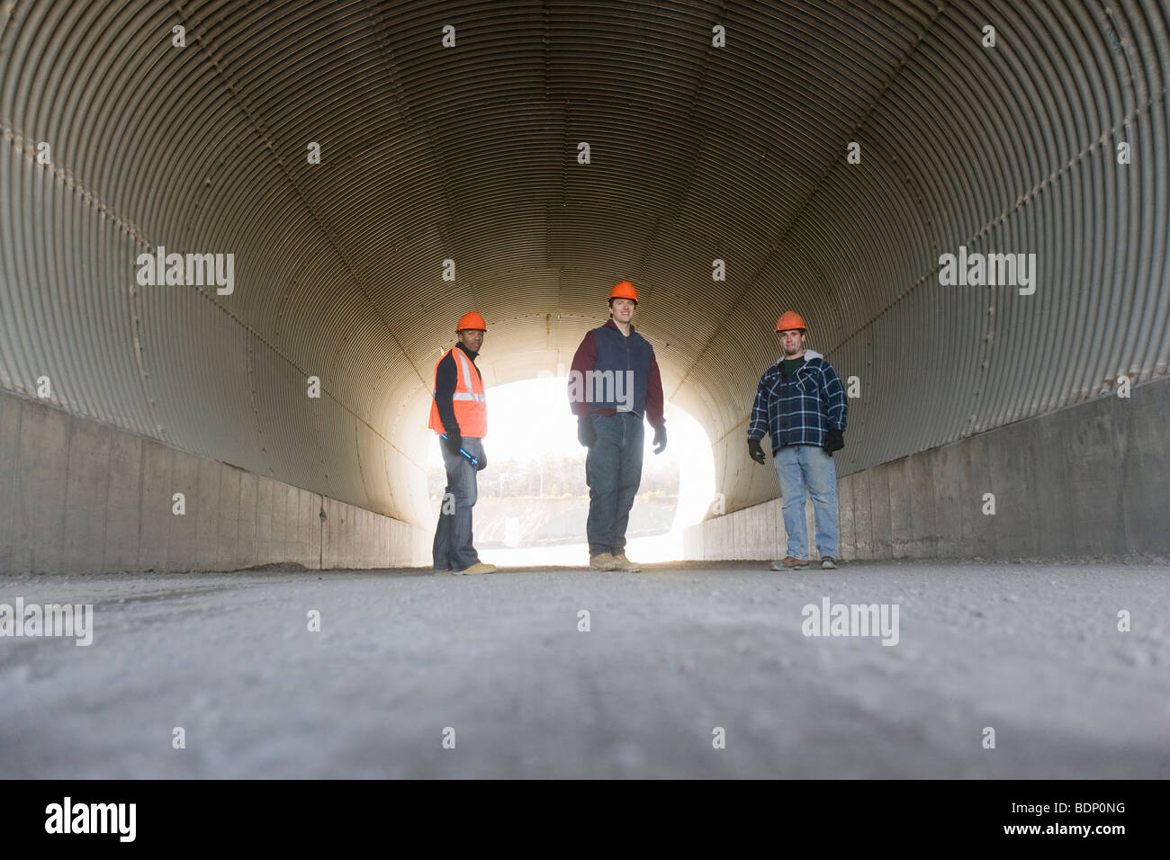 Three engineers standing in a tunnel Stock Photo - Alamy
