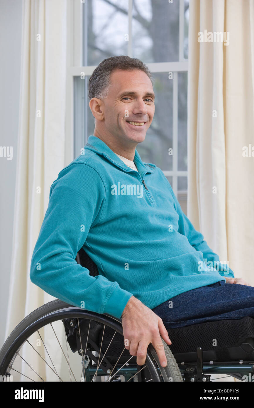 Man sitting in a wheelchair and smiling Stock Photo - Alamy