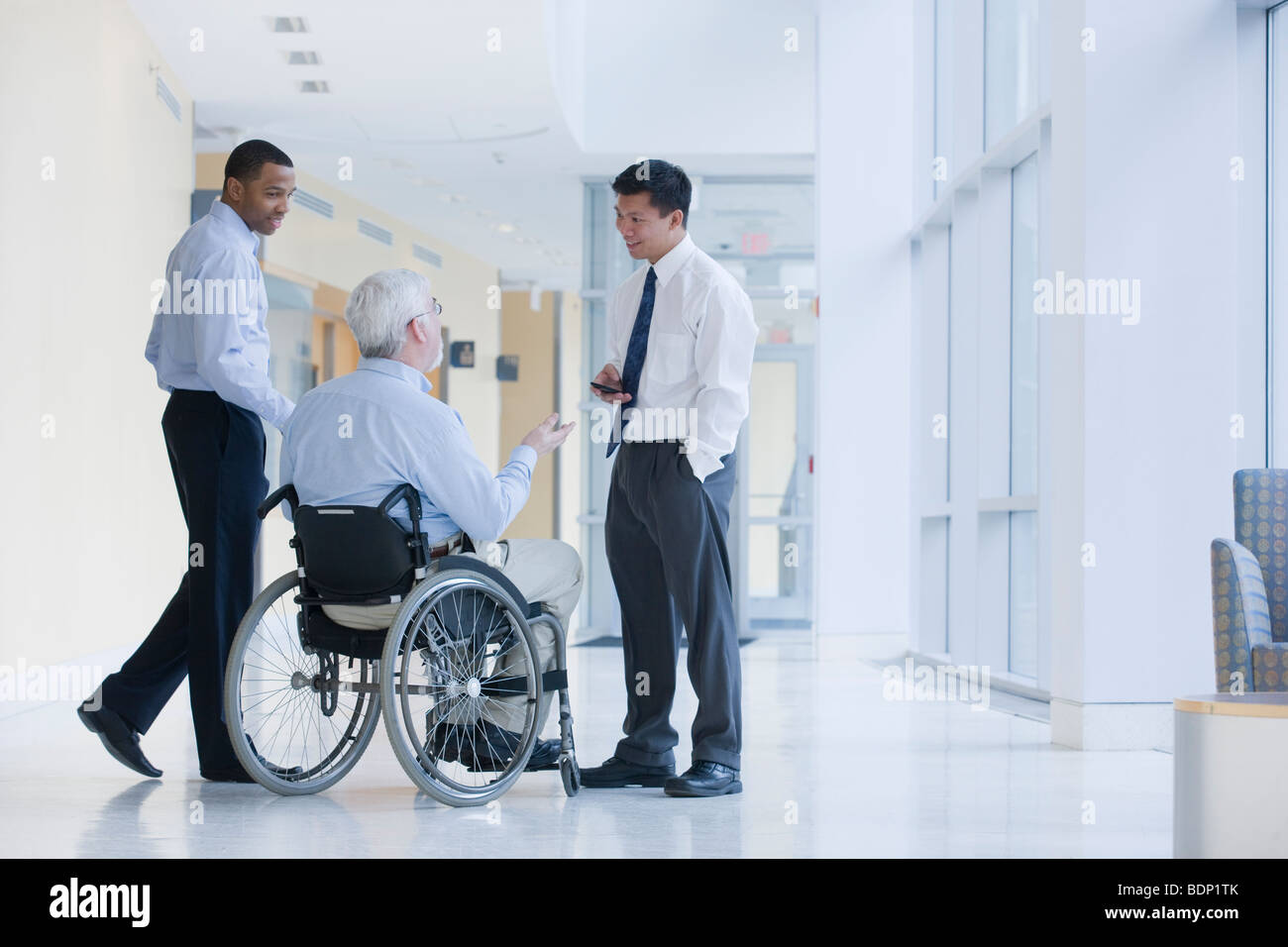 Three university professors talking in a corridor of a university Stock ...