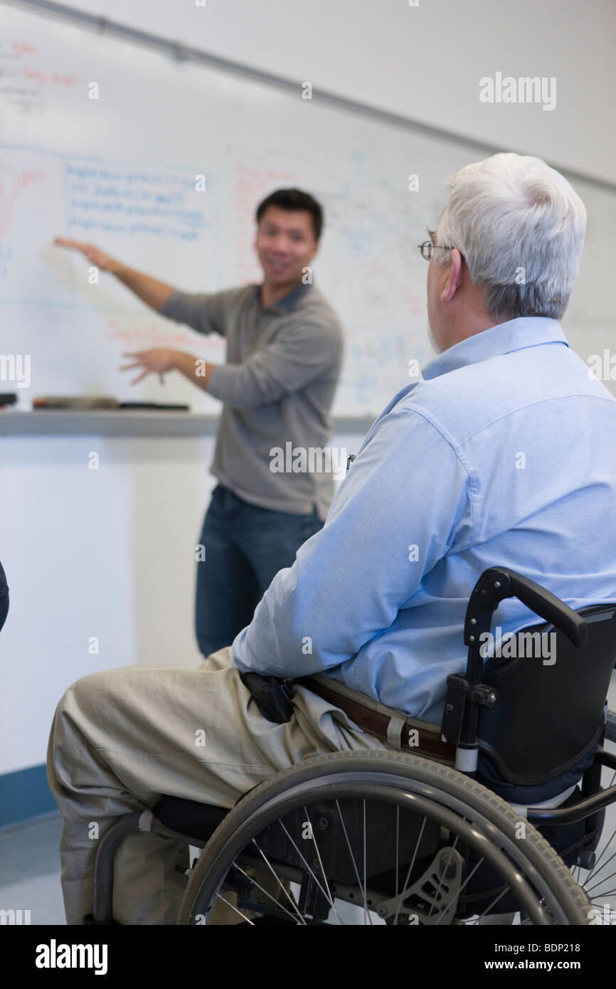 Student explaining to professor in a classroom Stock Photo - Alamy