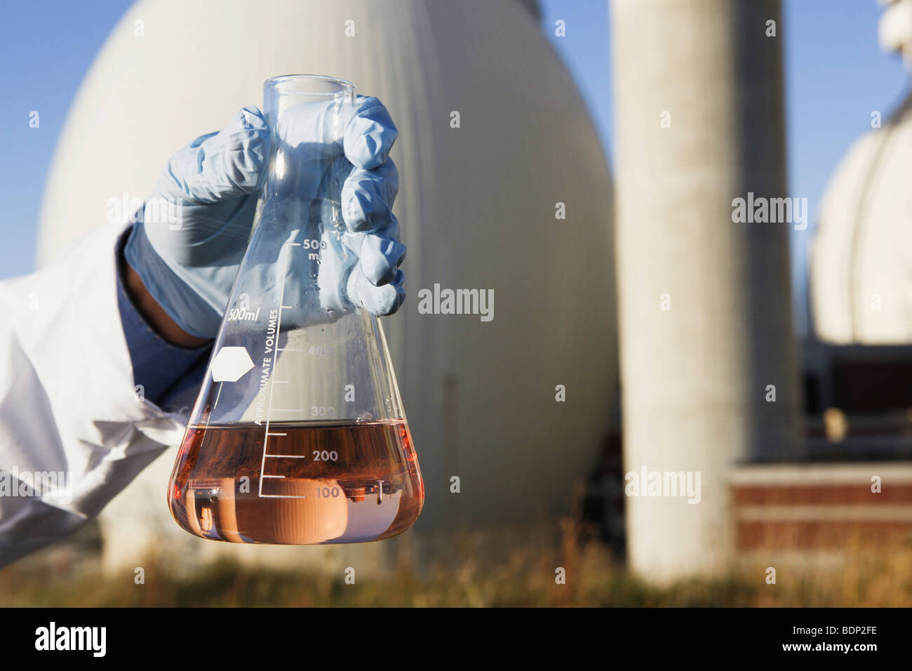 Scientist's hand holding a flask of water sample Stock Photo - Alamy