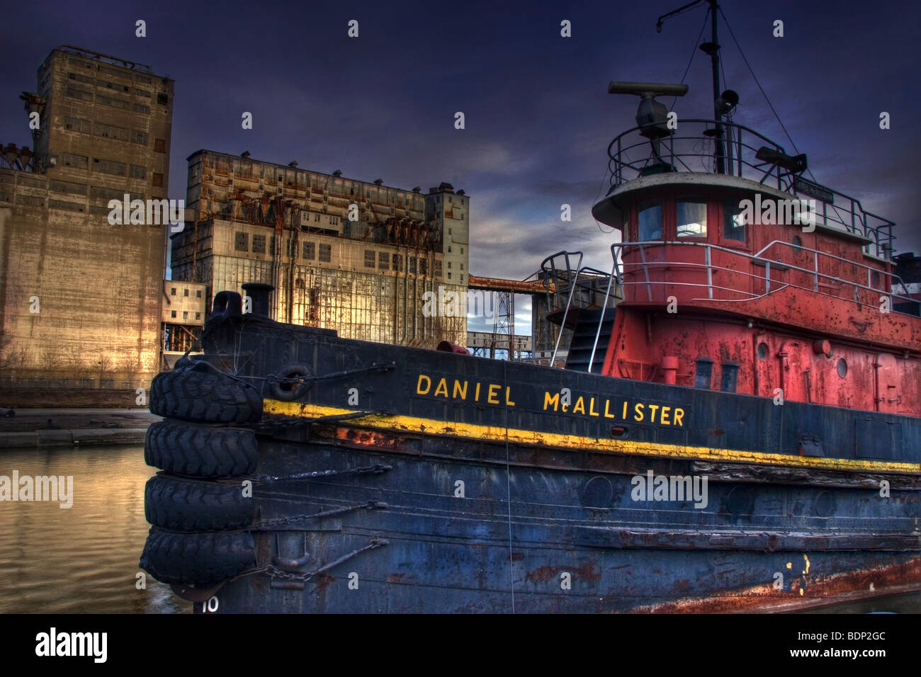 An old tug boat near to industrial buildings Stock Photo - Alamy