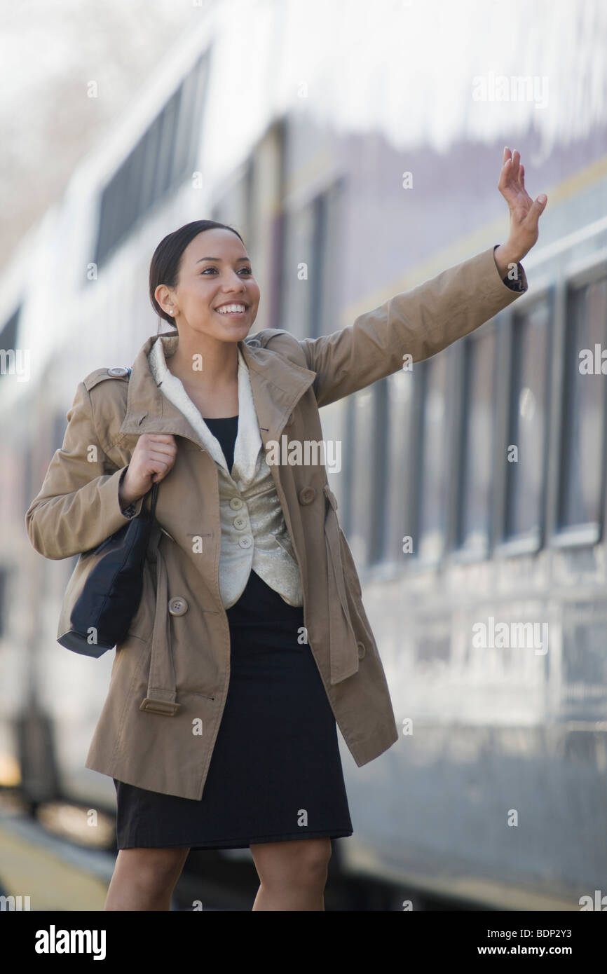 Hispanic woman waving goodbye at a railroad station platform Stock ...