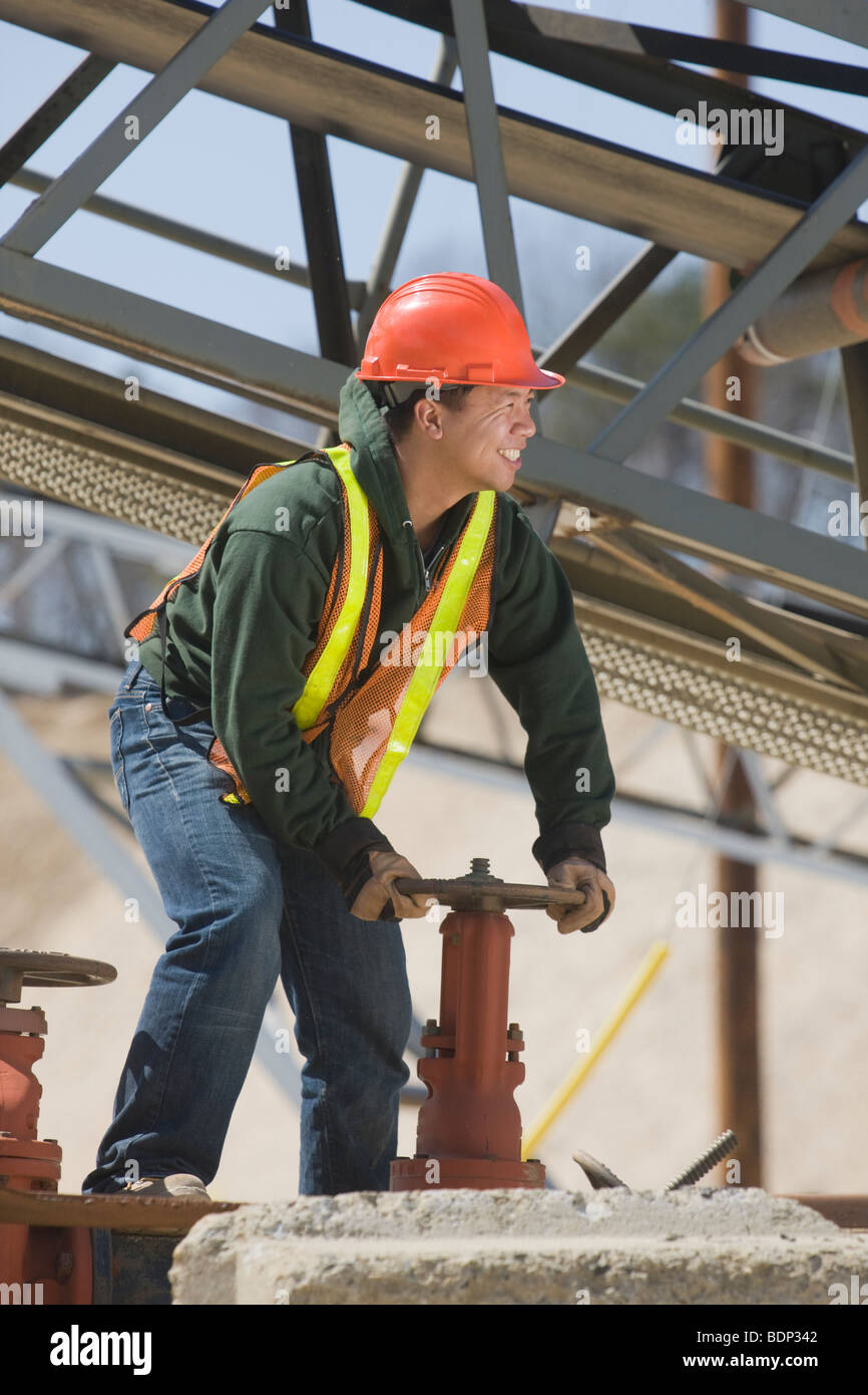 Engineer turning valve at a plant Stock Photo - Alamy