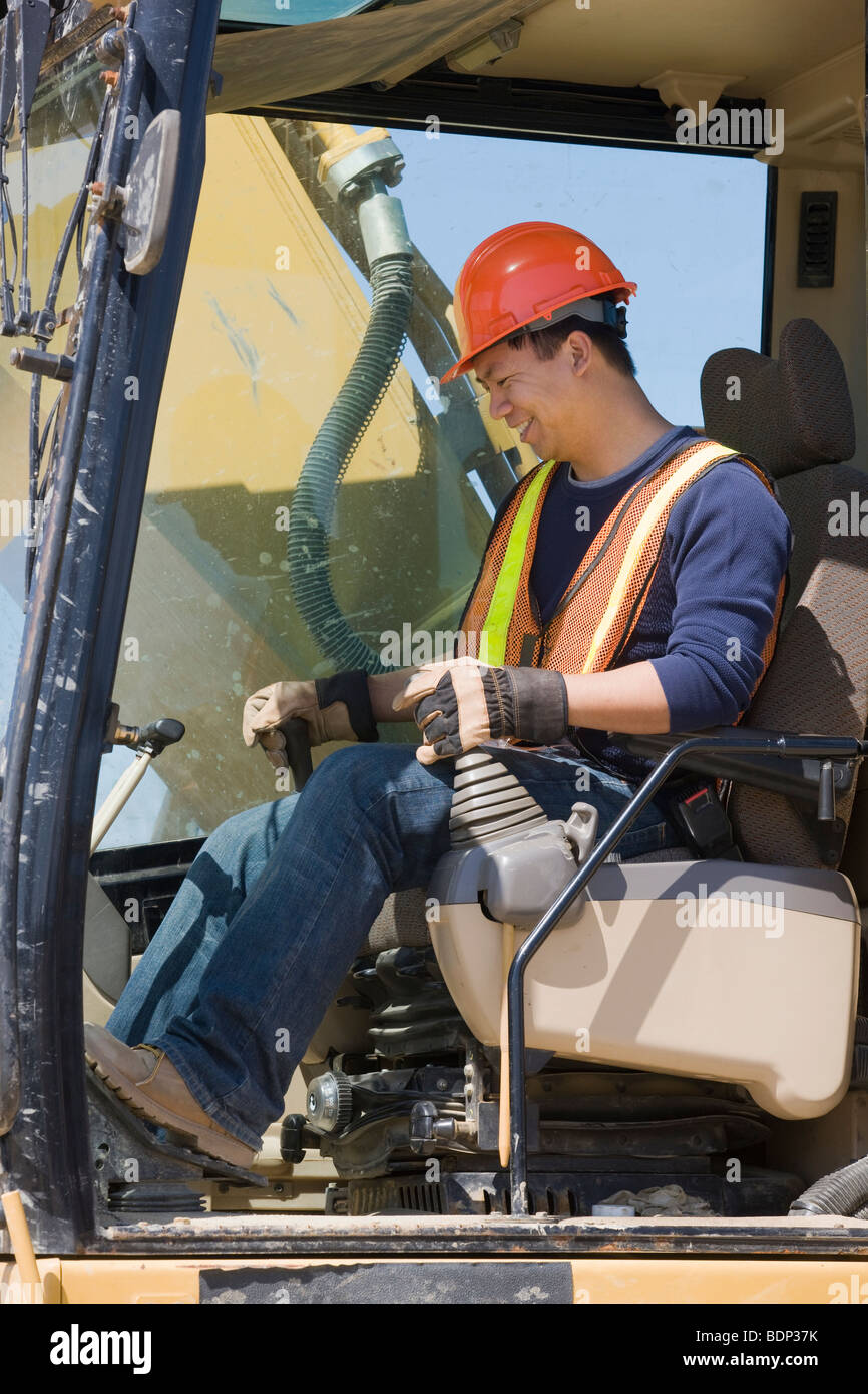 Engineer operating an earth mover at a plant Stock Photo - Alamy