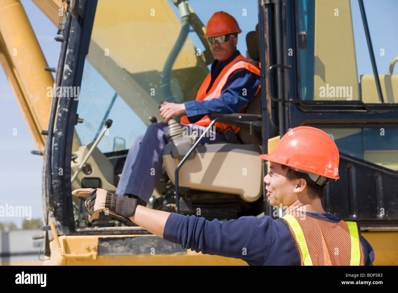 Two engineers operating an earth mover at a plant Stock Photo - Alamy