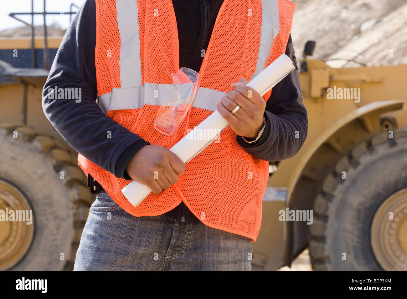 Engineer holding a blueprint at a construction site Stock Photo - Alamy